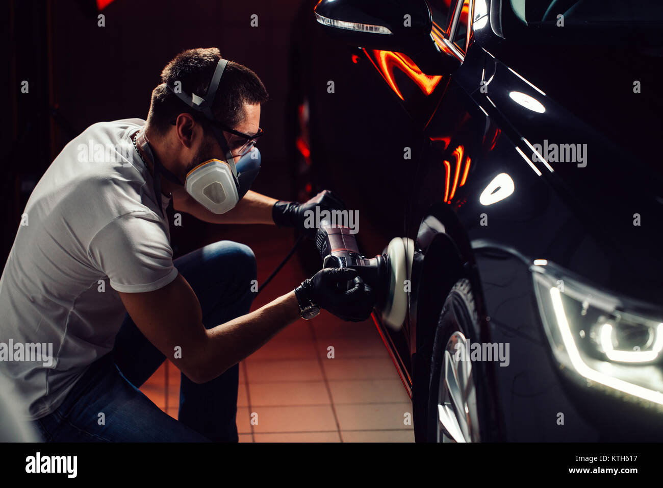 Car detailing - man with orbital polisher in auto repair shop ...