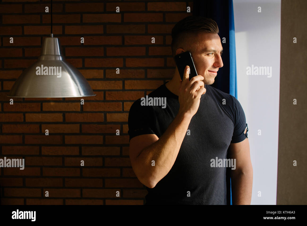 man talking on phone in home near window Stock Photo - Alamy