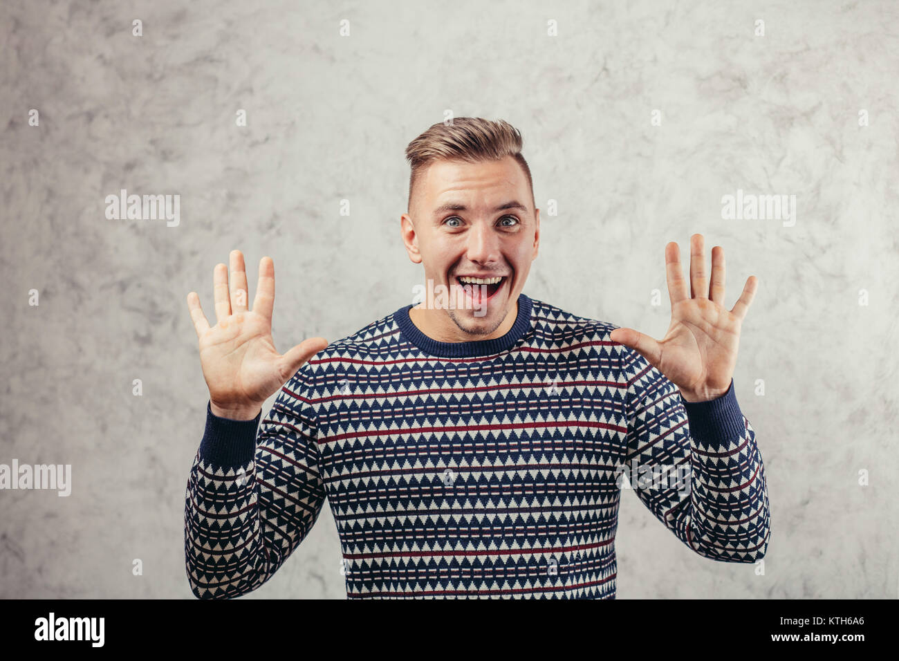 surprised man holded hands on head on concrete wall Stock Photo - Alamy