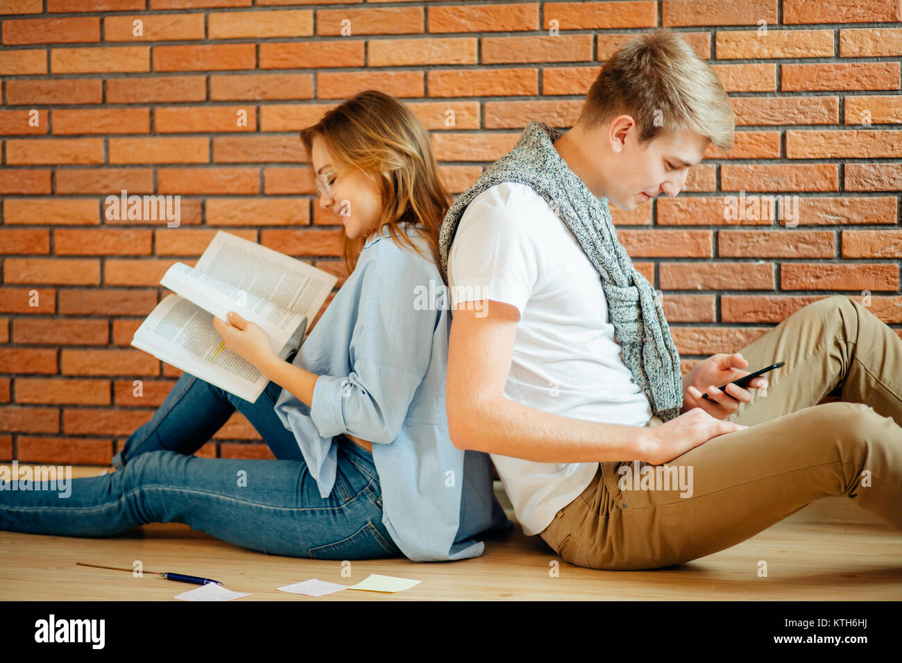 Couple students sitting outside classroom and studying together Stock ...