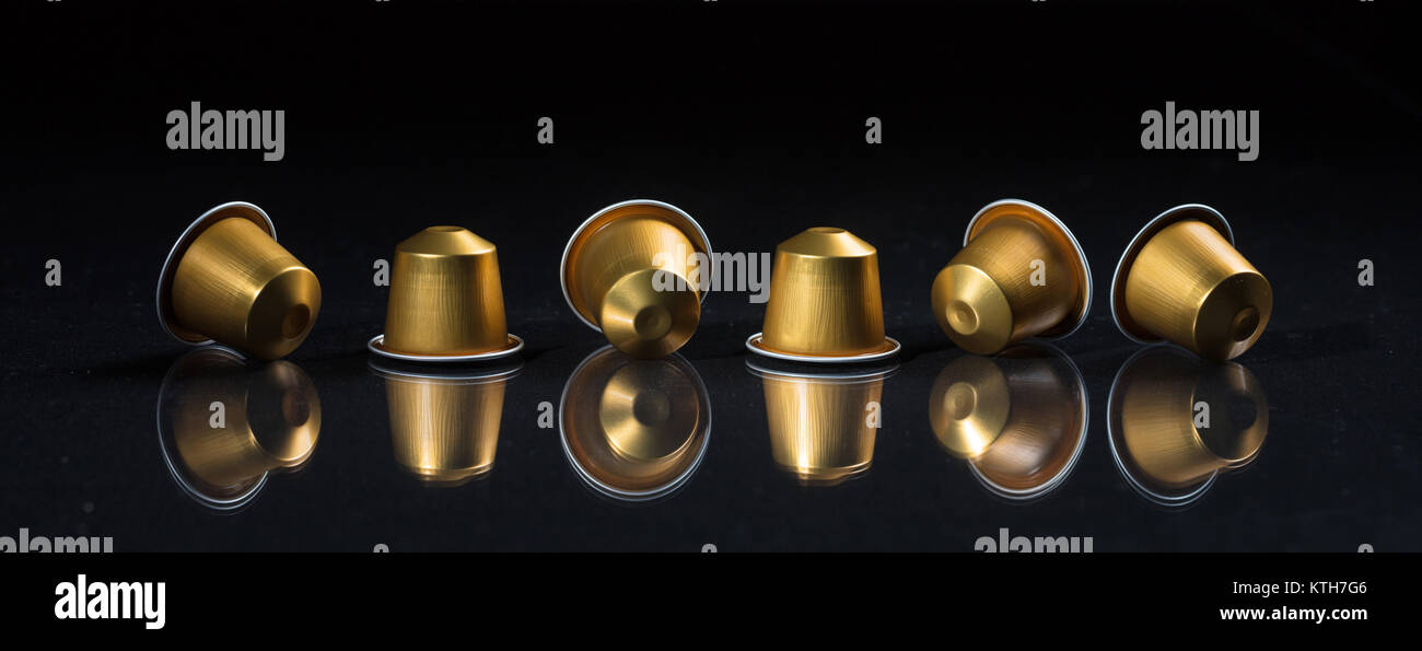 Golden espresso coffee capsules isolated on black background, Closeup ...