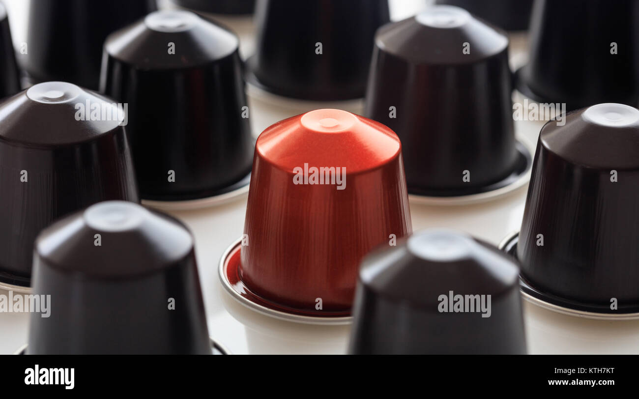 Collection of red and black espresso coffee capsules on white ...