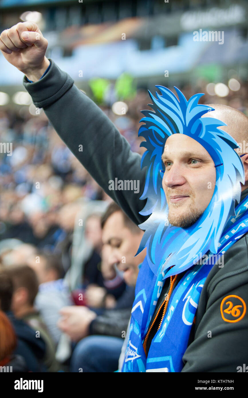 Fan with stretched hand wearing blue and white clothes. Football game ...