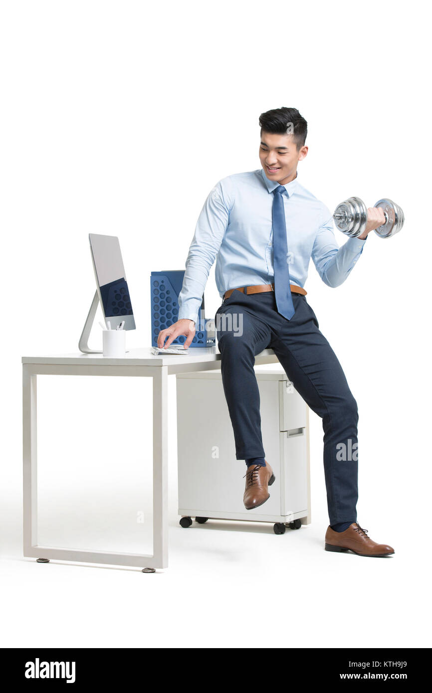 Young businessman lifting weights in office Stock Photo - Alamy