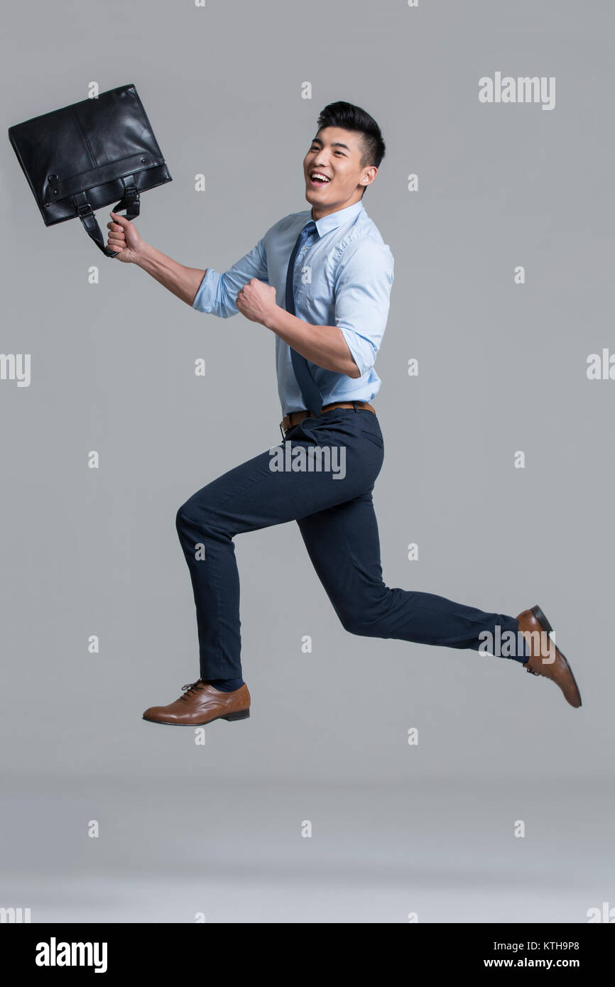 Cheerful young businessman punching the air Stock Photo - Alamy