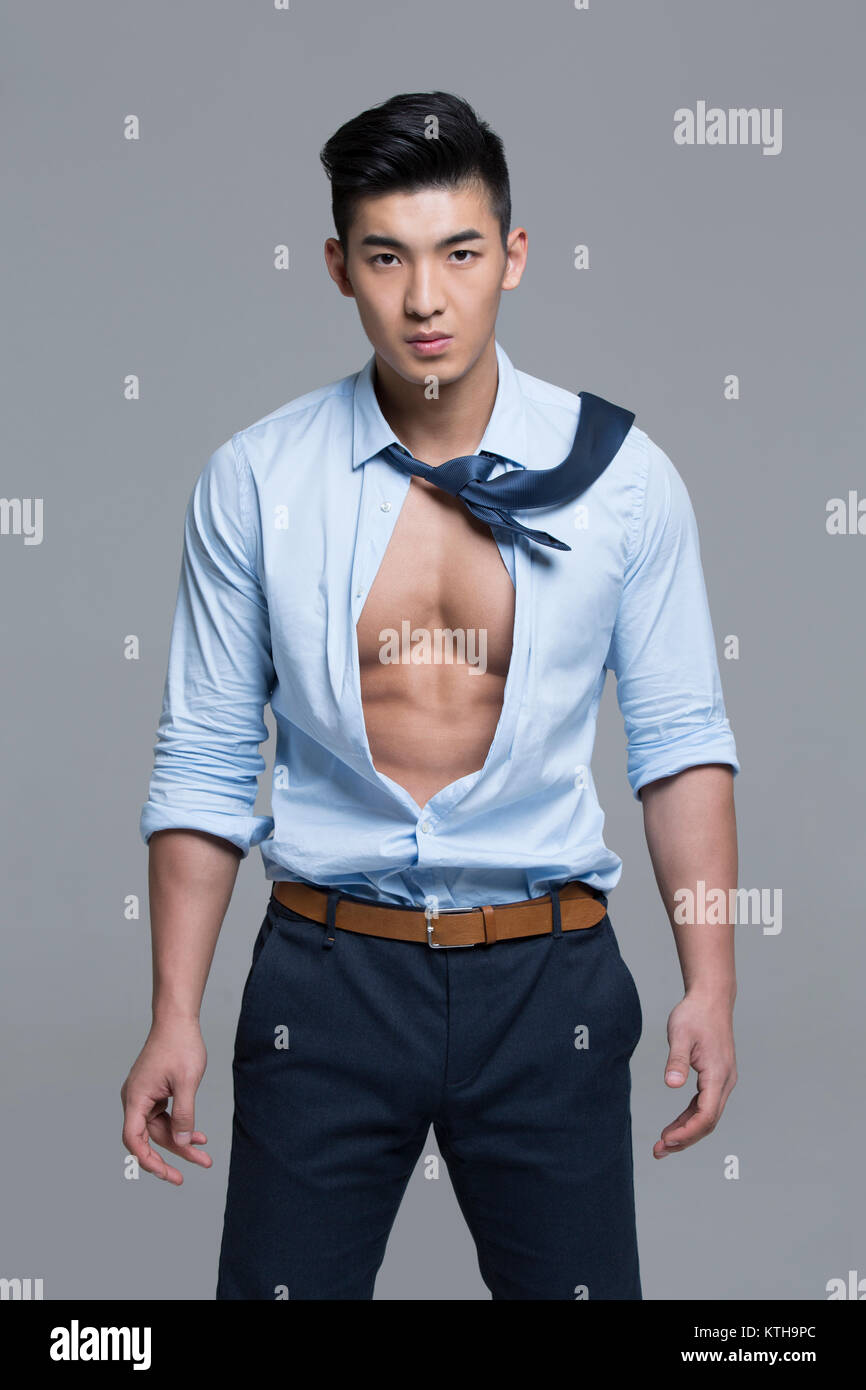 Young businessman showing muscles Stock Photo - Alamy