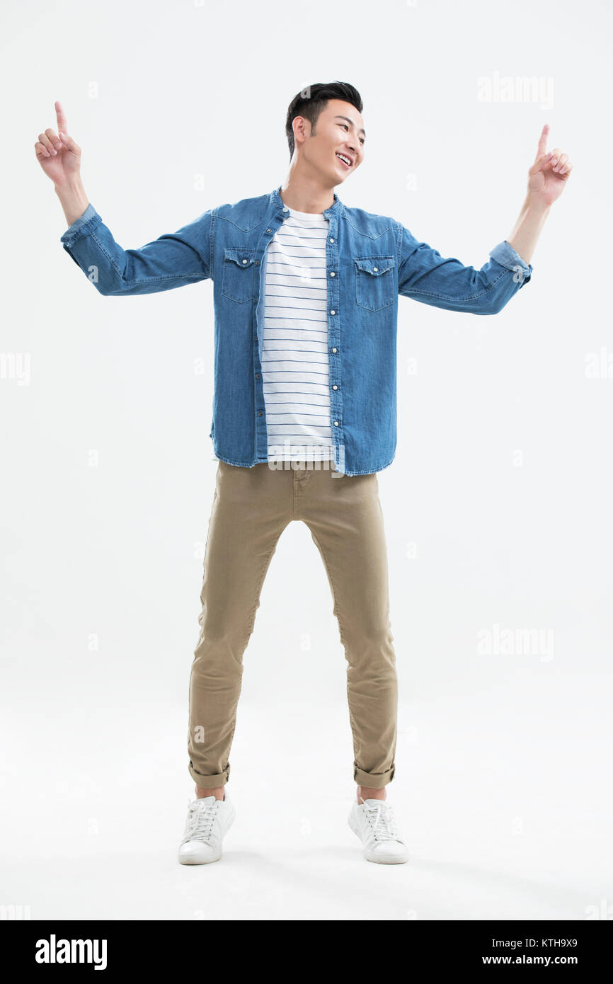 Cheerful young man pointing finger hi-res stock photography and images ...