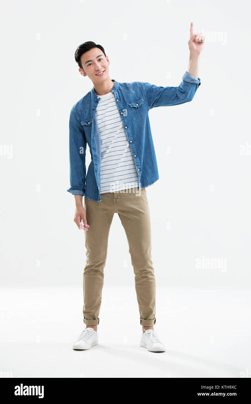 Cheerful young man pointing Stock Photo - Alamy