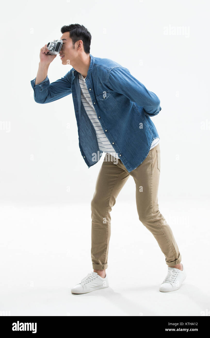 Young man taking photos with camera Stock Photo - Alamy