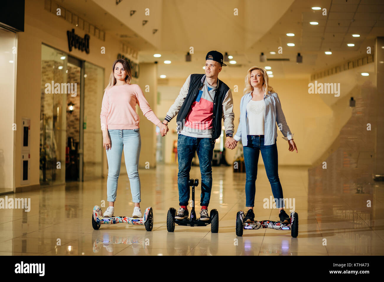 man and two woman riding on Hoverboard in mall Stock Photo - Alamy