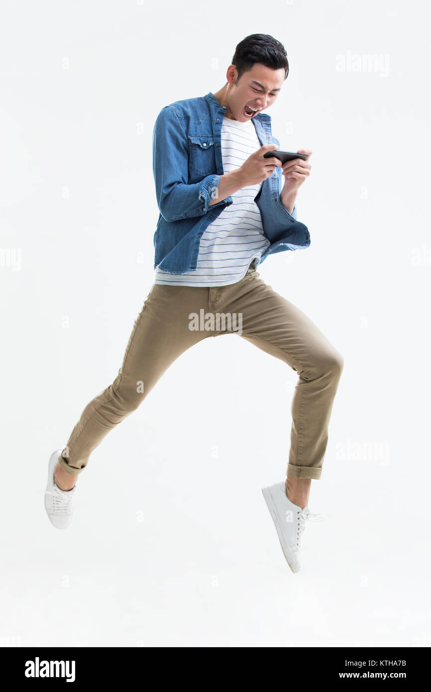 Young man jumping mobile phone hi-res stock photography and images - Alamy