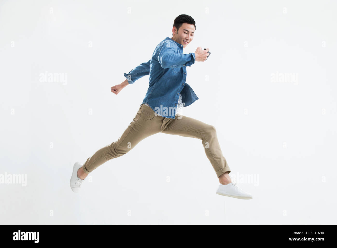 Young man jumping with a smart phone Stock Photo - Alamy