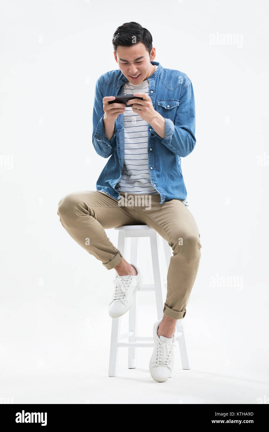 Young man playing mobile games Stock Photo - Alamy