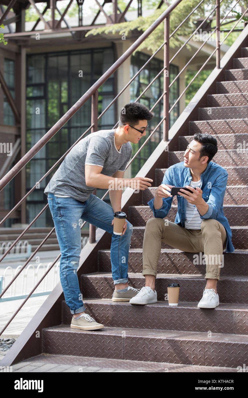 Young men having coffee break outdoors Stock Photo - Alamy