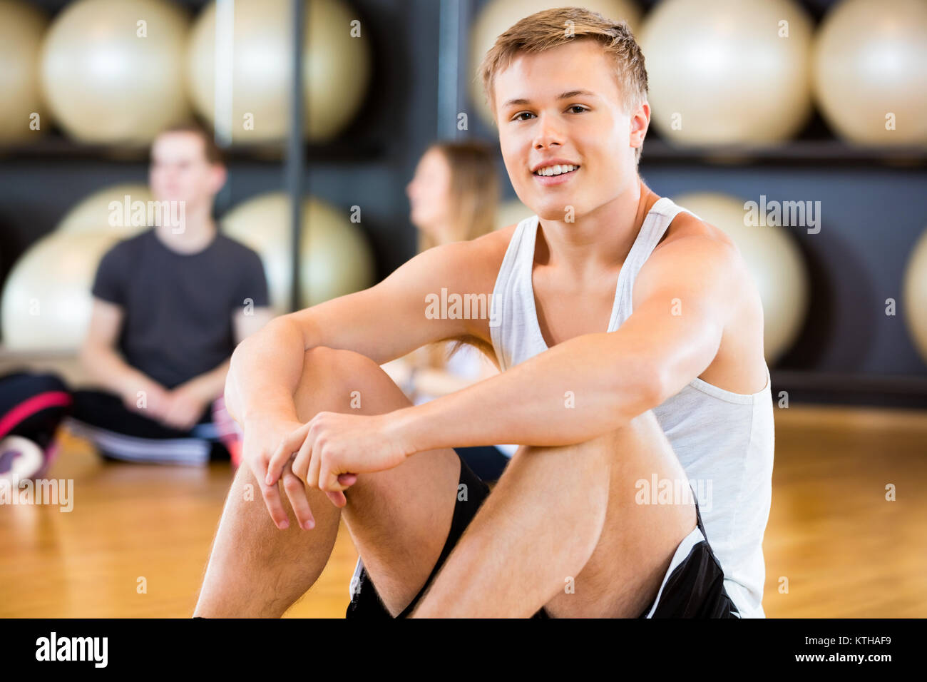 Confident Man Sitting In Fitness Studio Stock Photo - Alamy