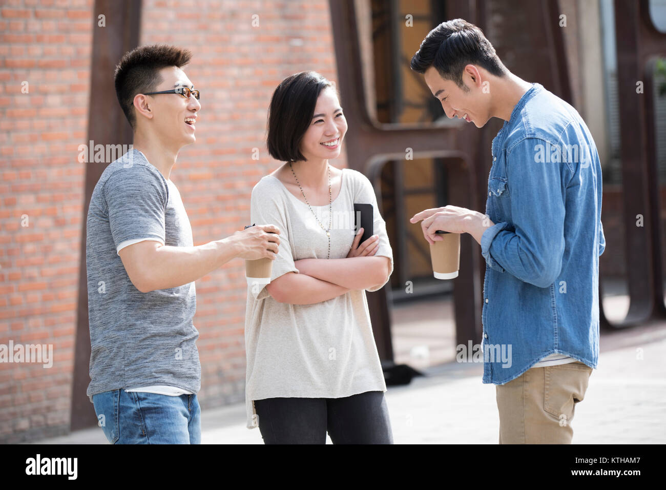 Cheerful young friends talking outdoors Stock Photo - Alamy