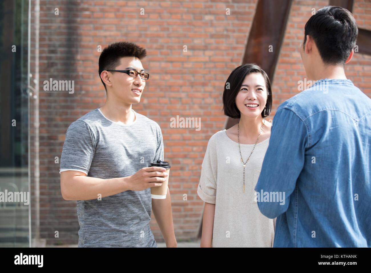 Cheerful young friends talking outdoors Stock Photo - Alamy
