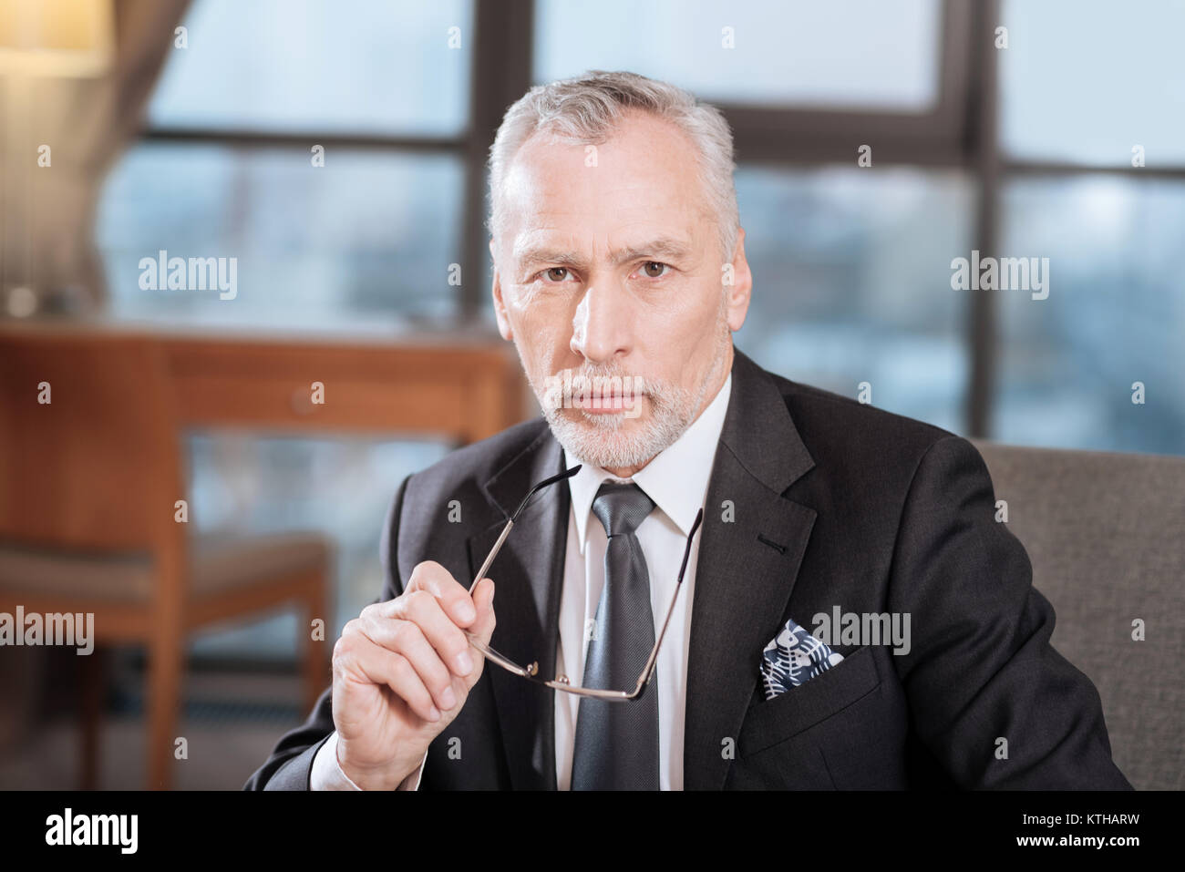 Senior man holding glasses hi-res stock photography and images - Alamy