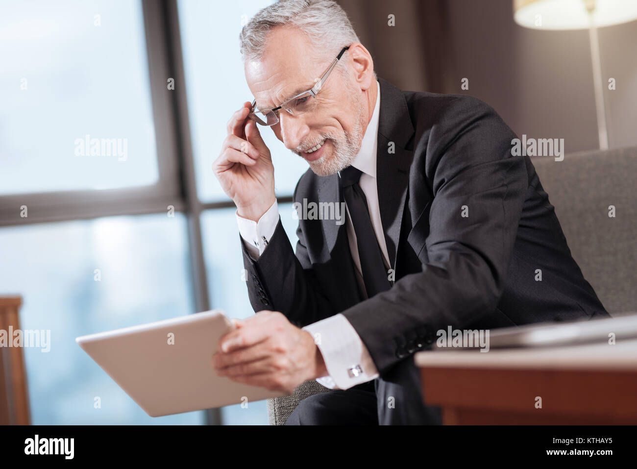 Senior handsome man evaluating project Stock Photo - Alamy