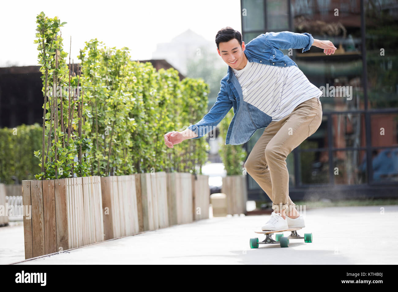 Cheerful young man skateboarding Stock Photo - Alamy