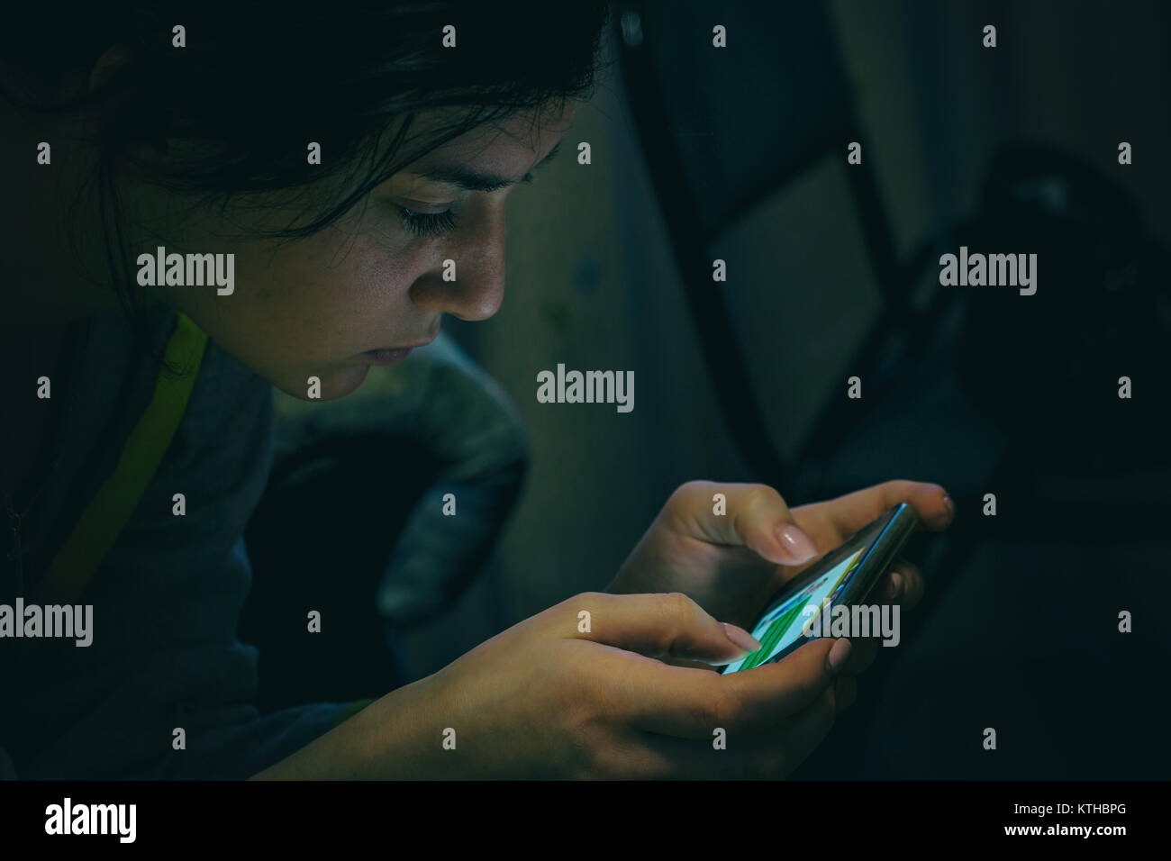 Girl in a dark room with smartphone Stock Photo - Alamy
