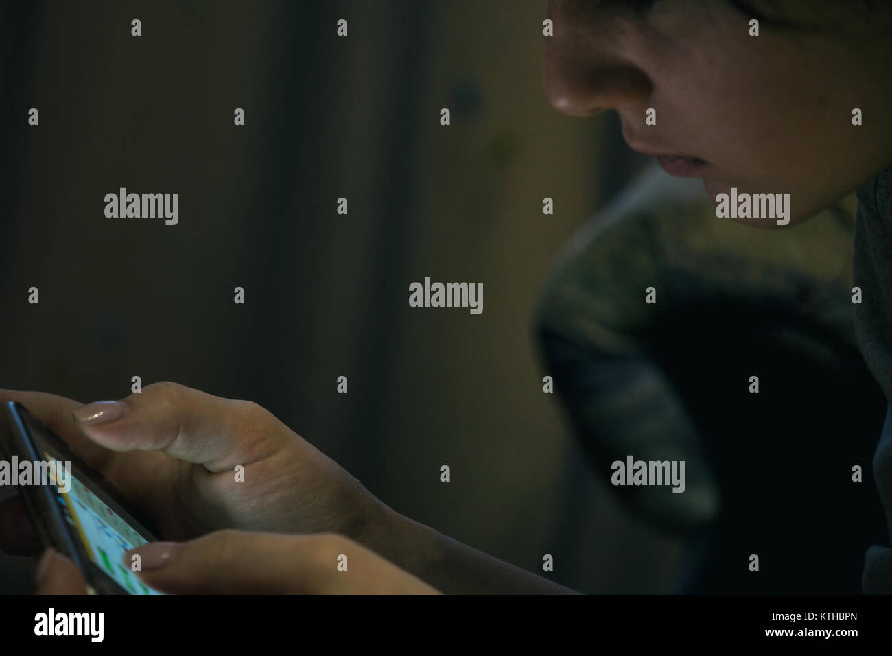 Girl in a dark room with smartphone Stock Photo - Alamy