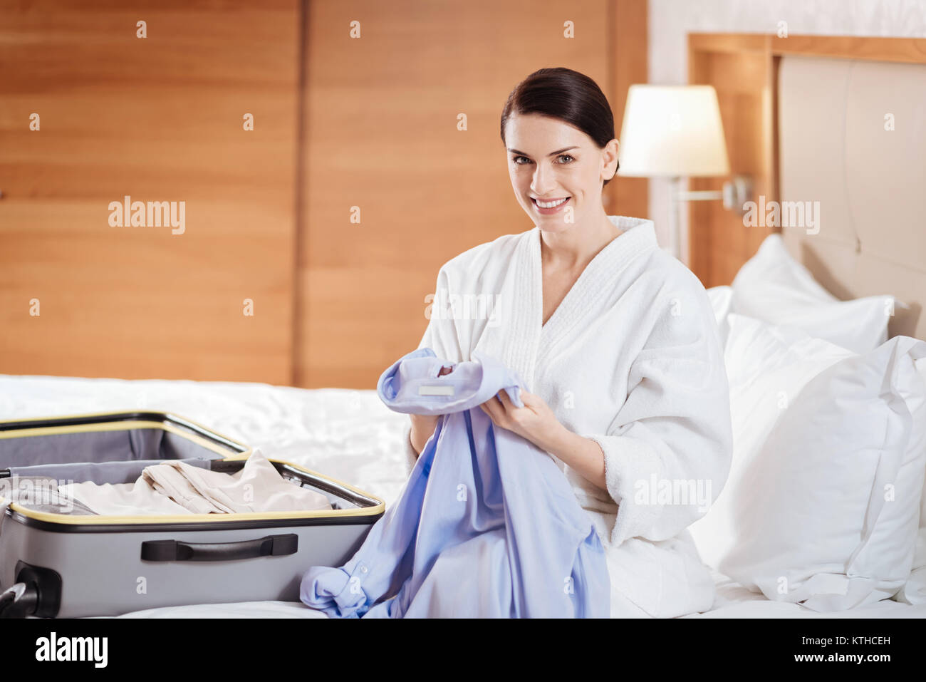 Cheerful jolly woman taking shirt Stock Photo - Alamy