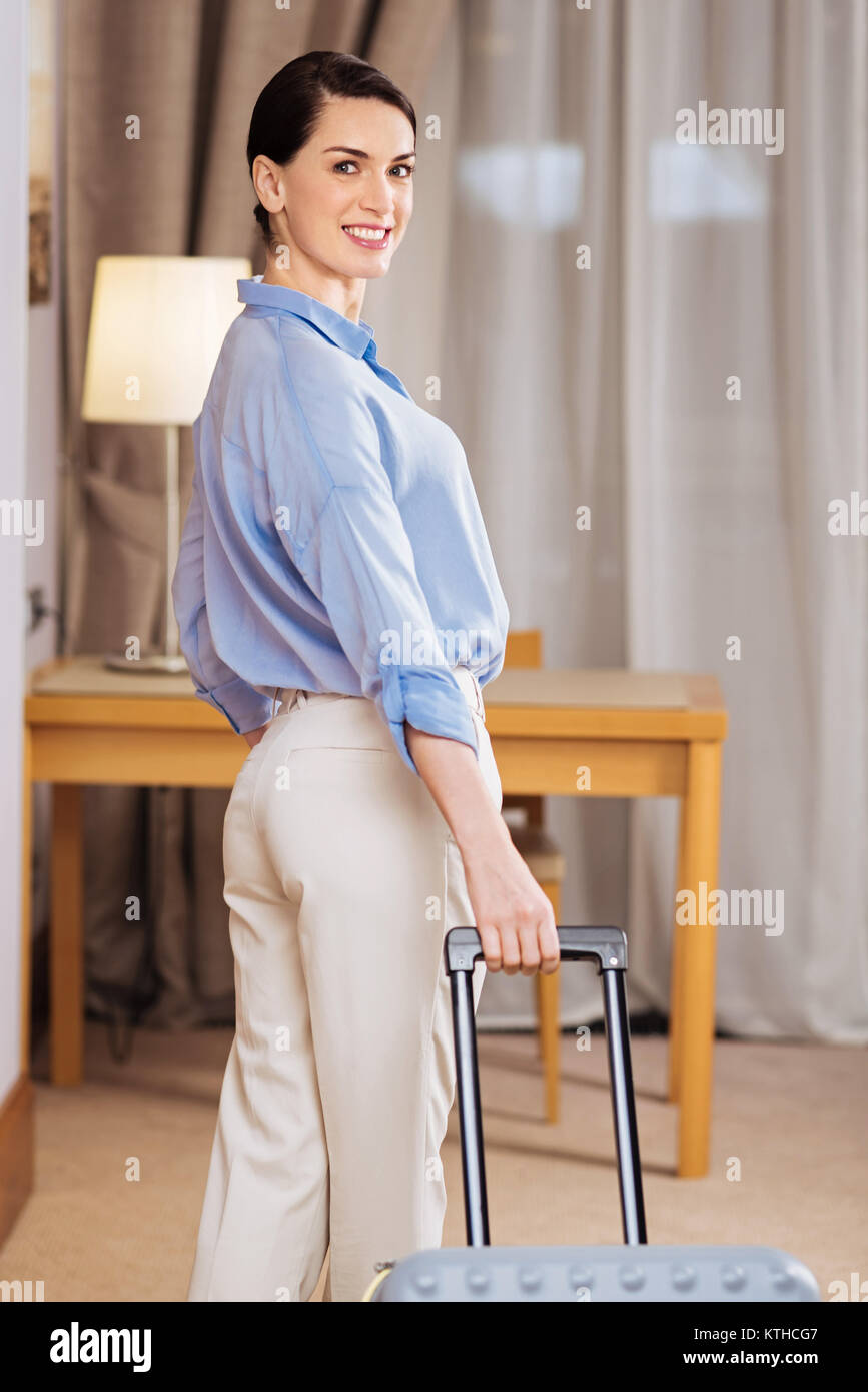 Pretty cheerful woman turning to say goodbye Stock Photo - Alamy