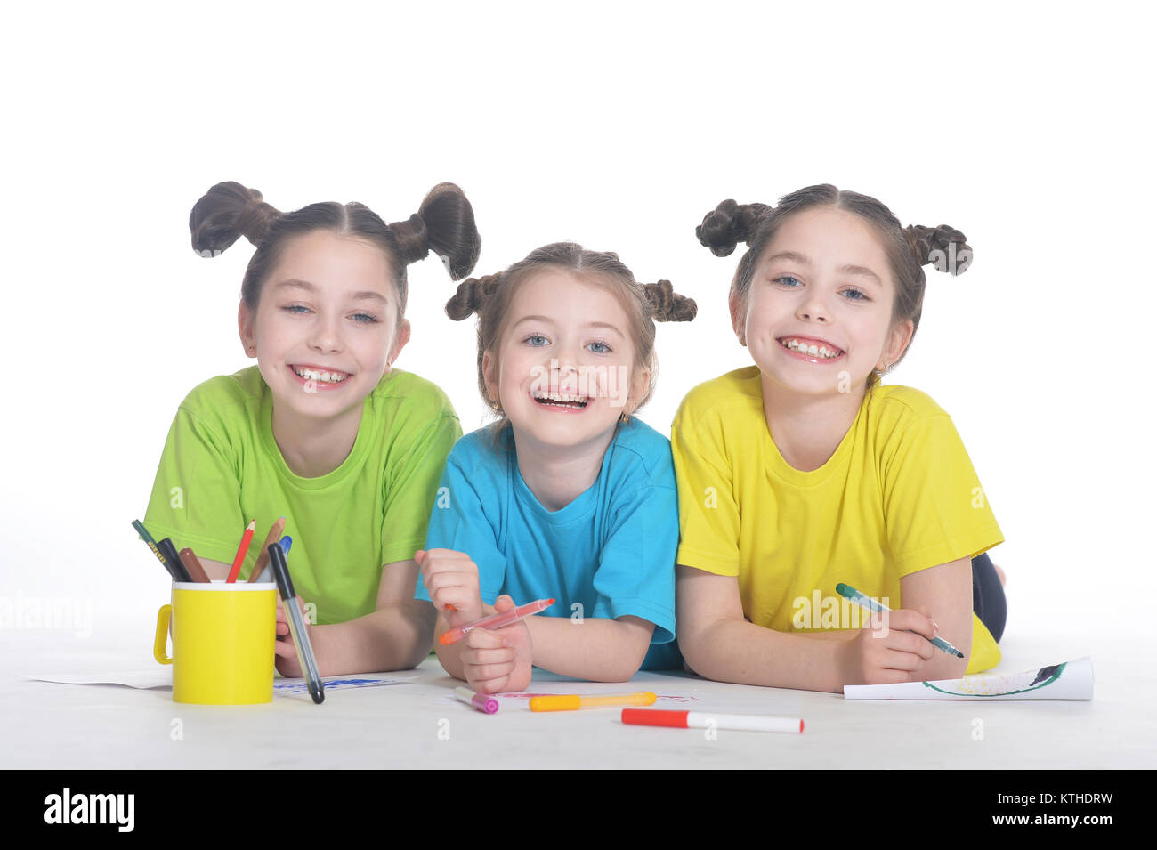 three cute little girls drawing together isolated on white background ...