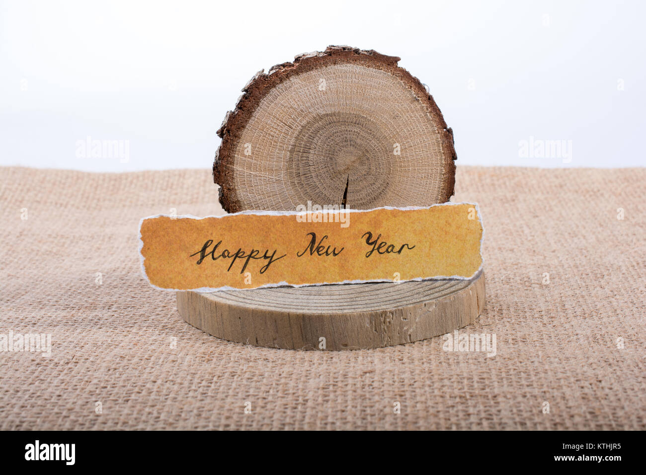 Happy new year written torn paper on a piece of log Stock Photo - Alamy