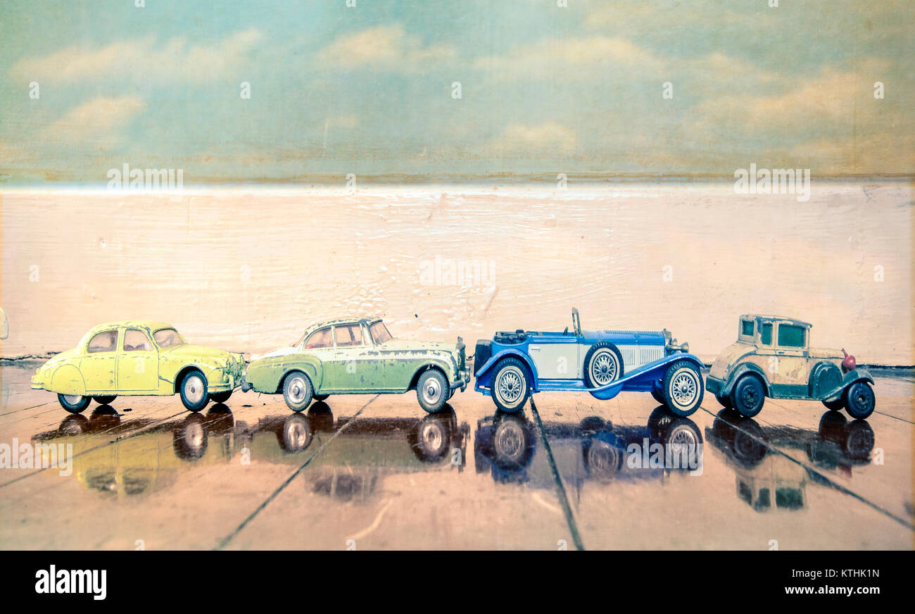 a line of retro tin toy cars on a wooden floor with reflection Stock ...