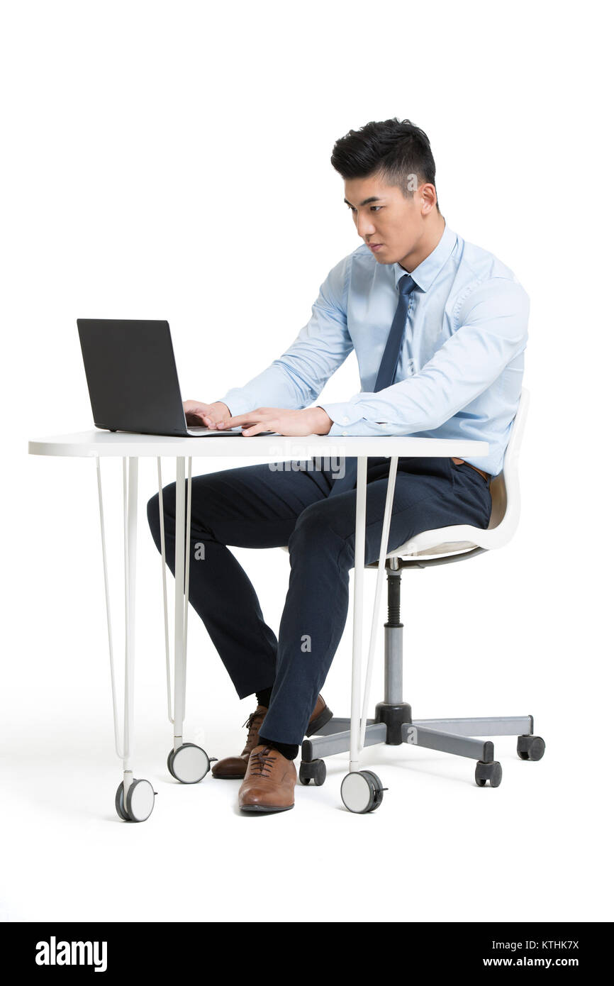 Young businessman using laptop at work Stock Photo - Alamy