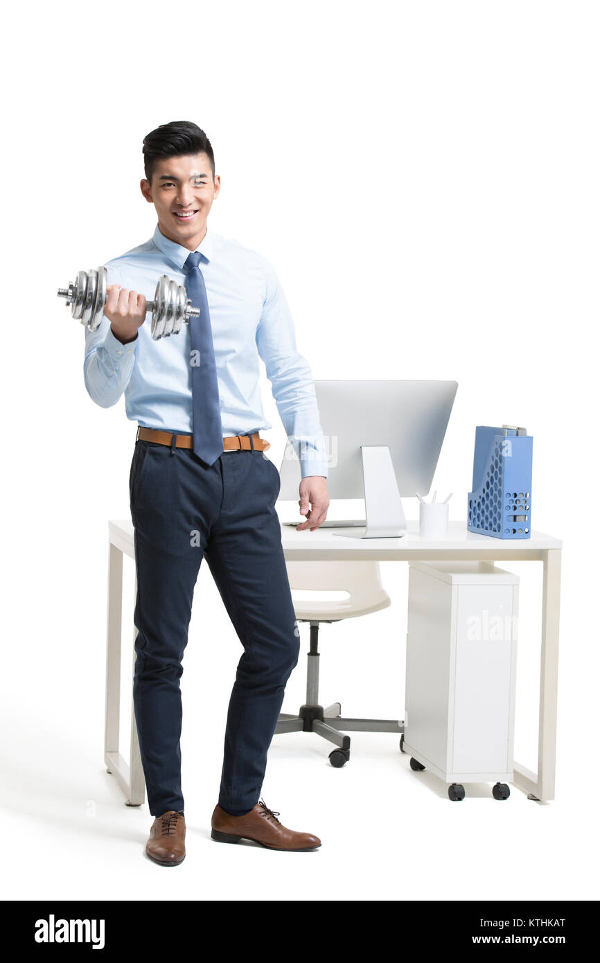Young businessman lifting weights in office Stock Photo - Alamy