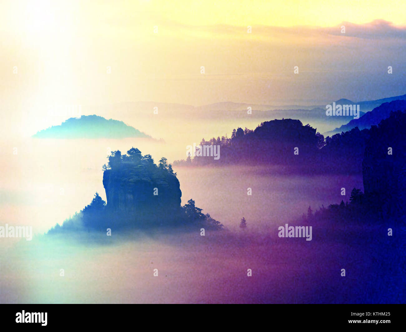 Abstract effect. Autumn sunrise in mountain within inversion. Peaks of ...