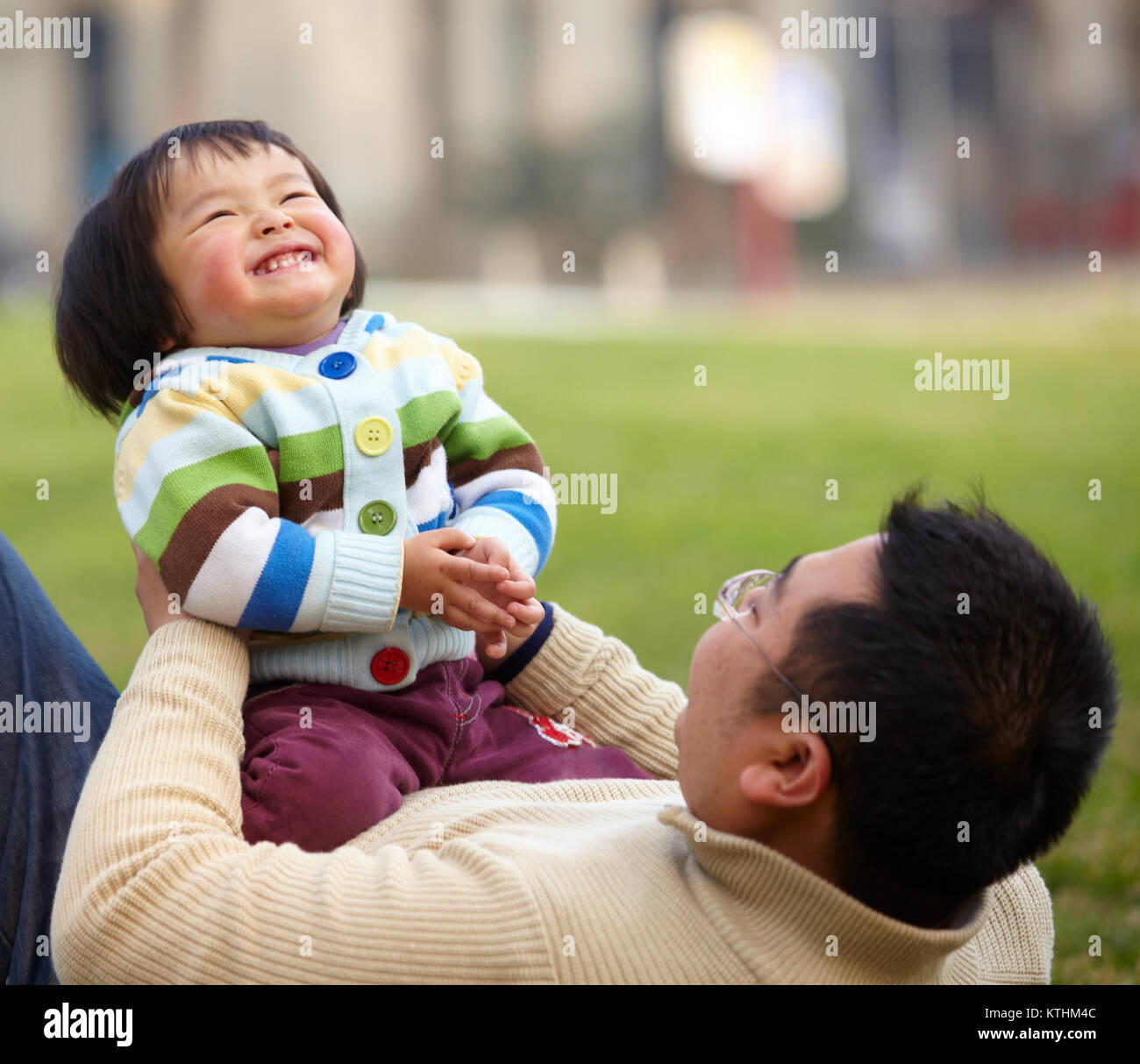 happy asian father playing with his little girl outdoor in the park ...