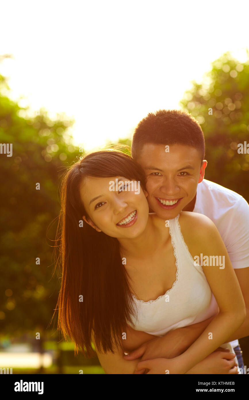 Young Chinese lover holding together in the park smile at camera in the ...