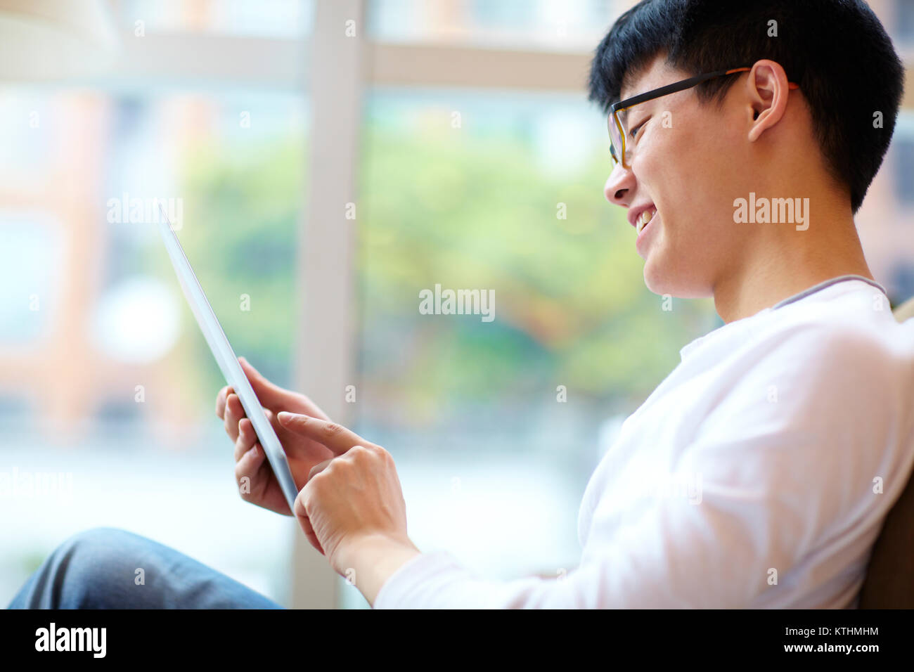 Chinese Young man using tablet in cafe Stock Photo - Alamy