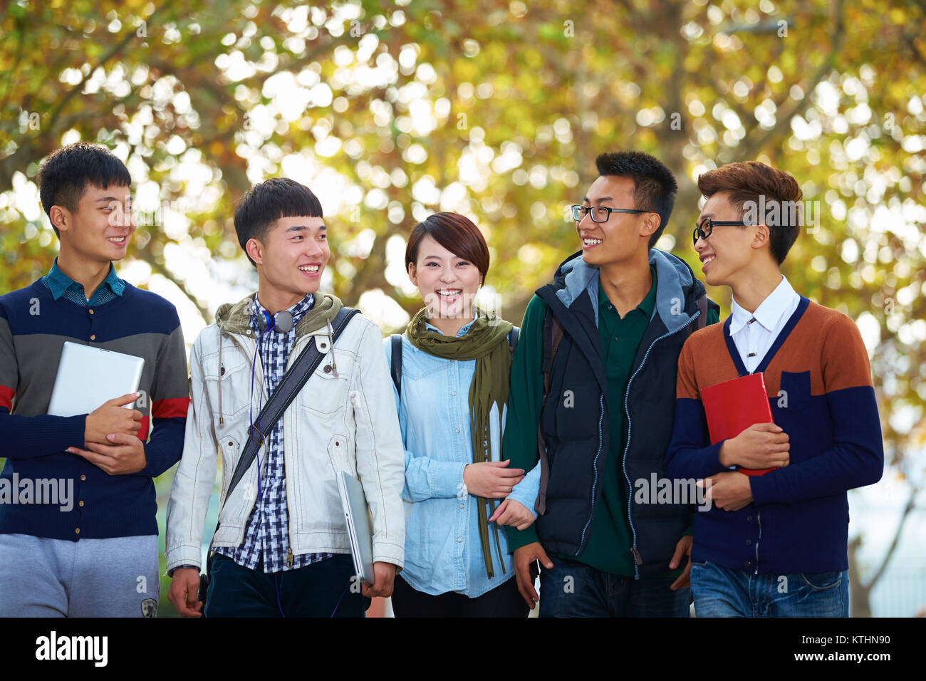 group of happy asian college students walking together in the campus ...