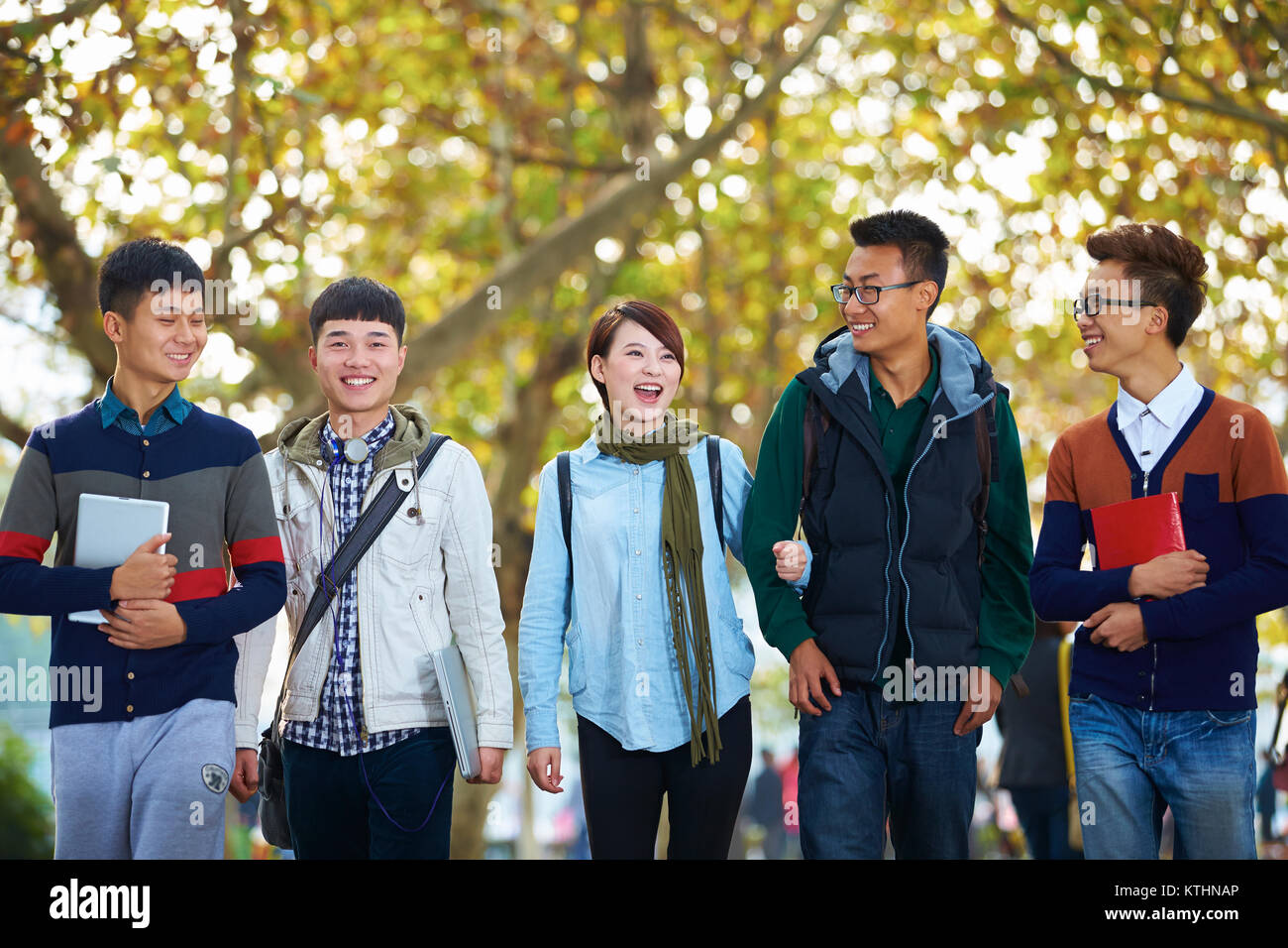 group of happy asian college students walking together in the campus ...
