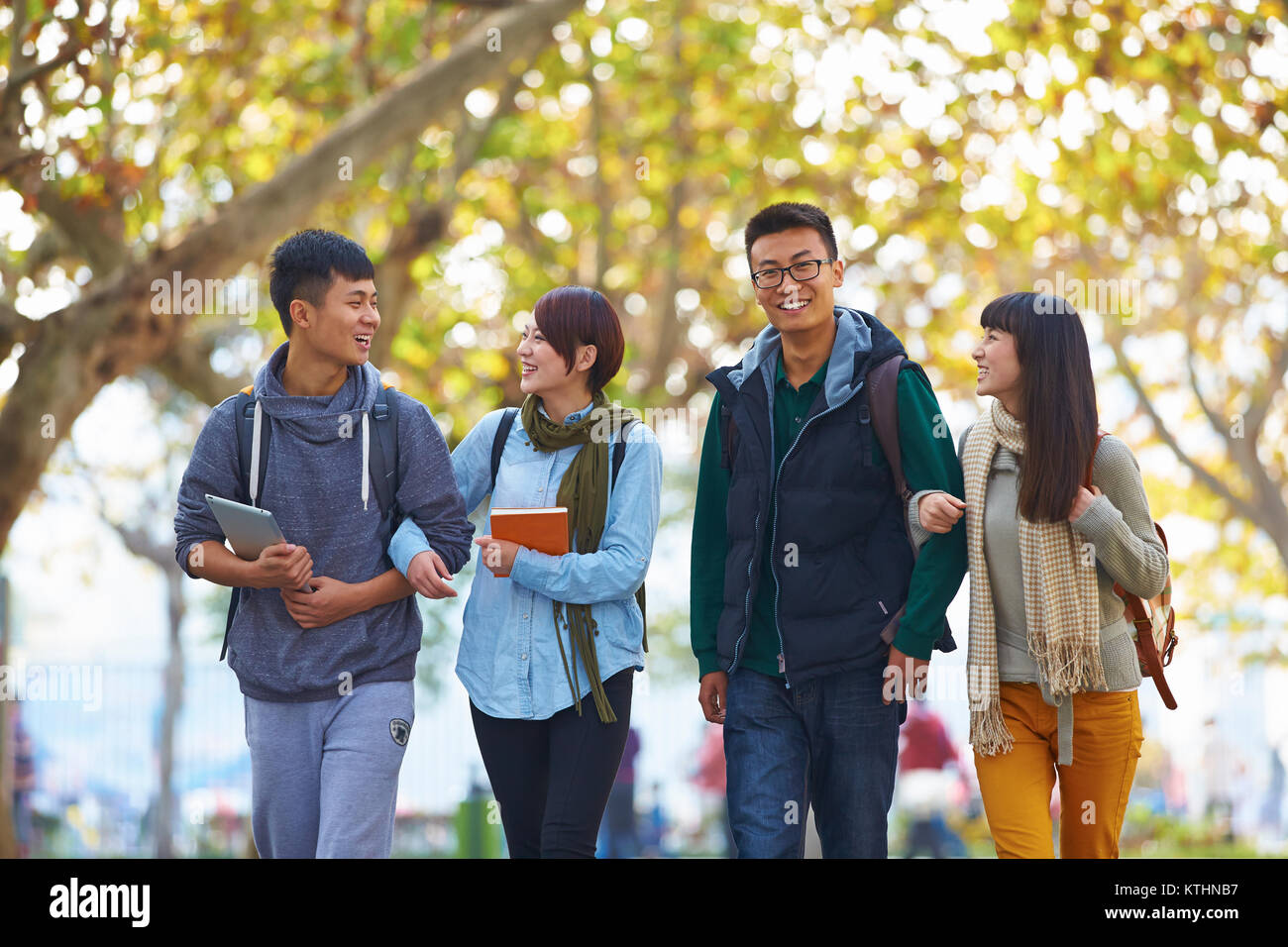 group of happy asian college students walking together in the campus ...