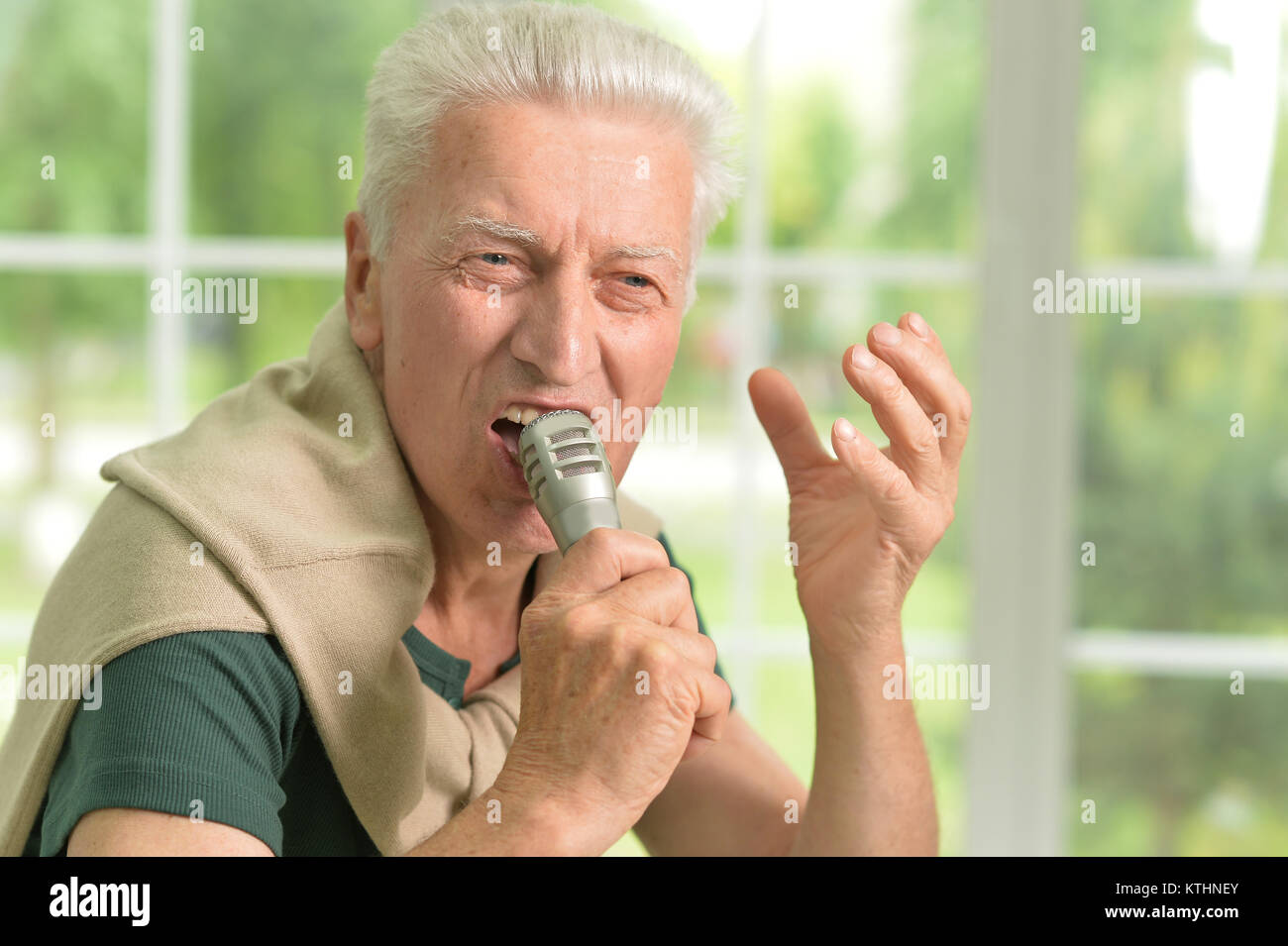excited senior man holding microphone Stock Photo - Alamy