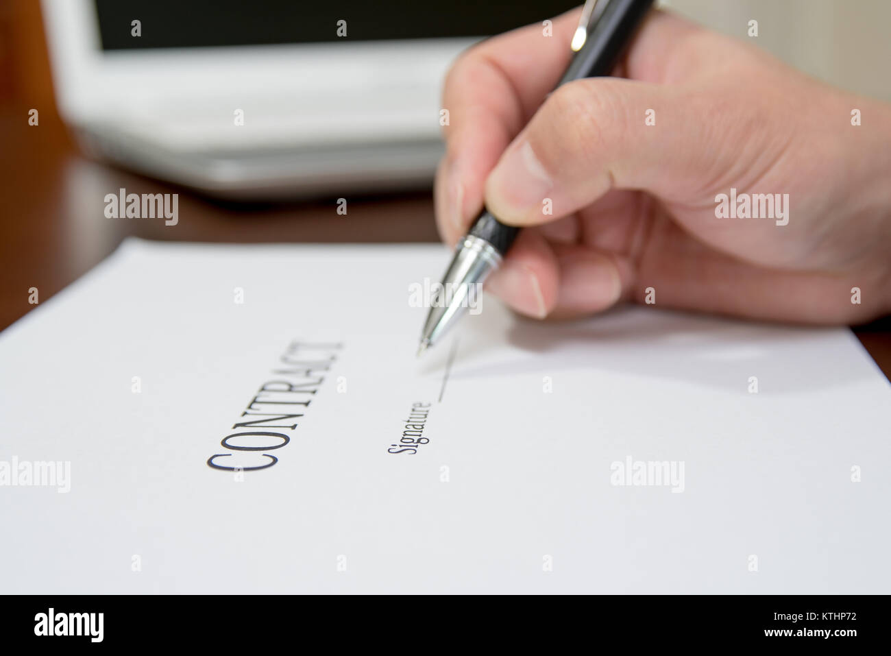 A concept of signing a contract holding a pen Stock Photo - Alamy