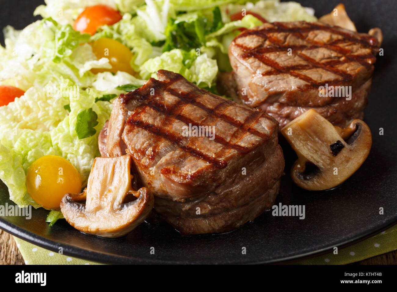 Juicy fillet mignon with fresh vegetable salad and mushrooms close-up ...