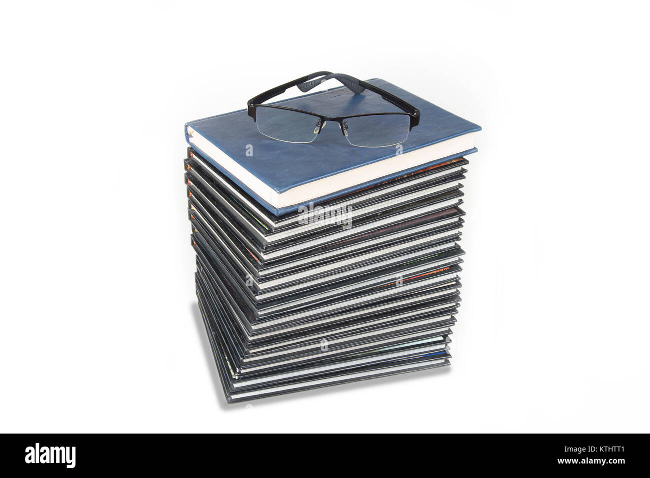 Stack of books with eyeglasses on the white background Stock Photo - Alamy