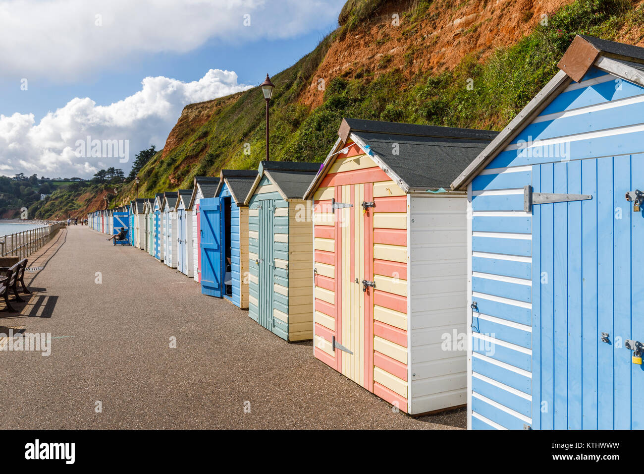Colourful beach huts under the cliffs along the seafront promenade at ...
