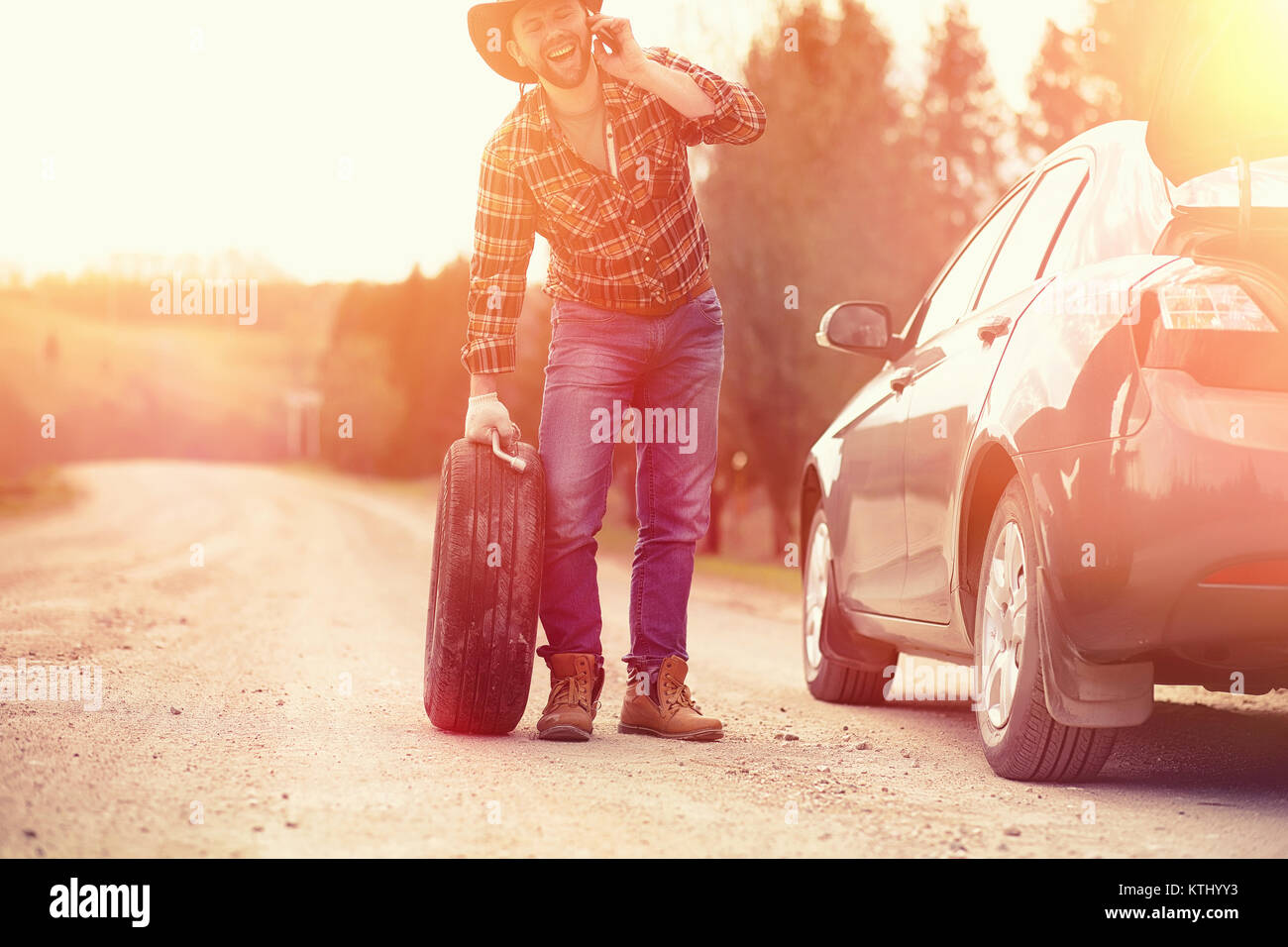 Man is sitting on the road by the car Stock Photo - Alamy