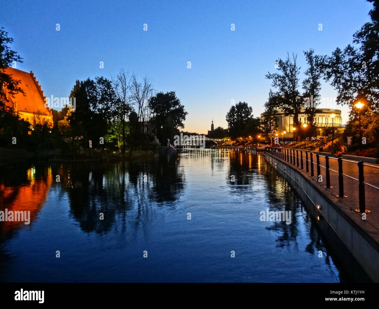 This image captures a view of the Brdy River embankment at night ...