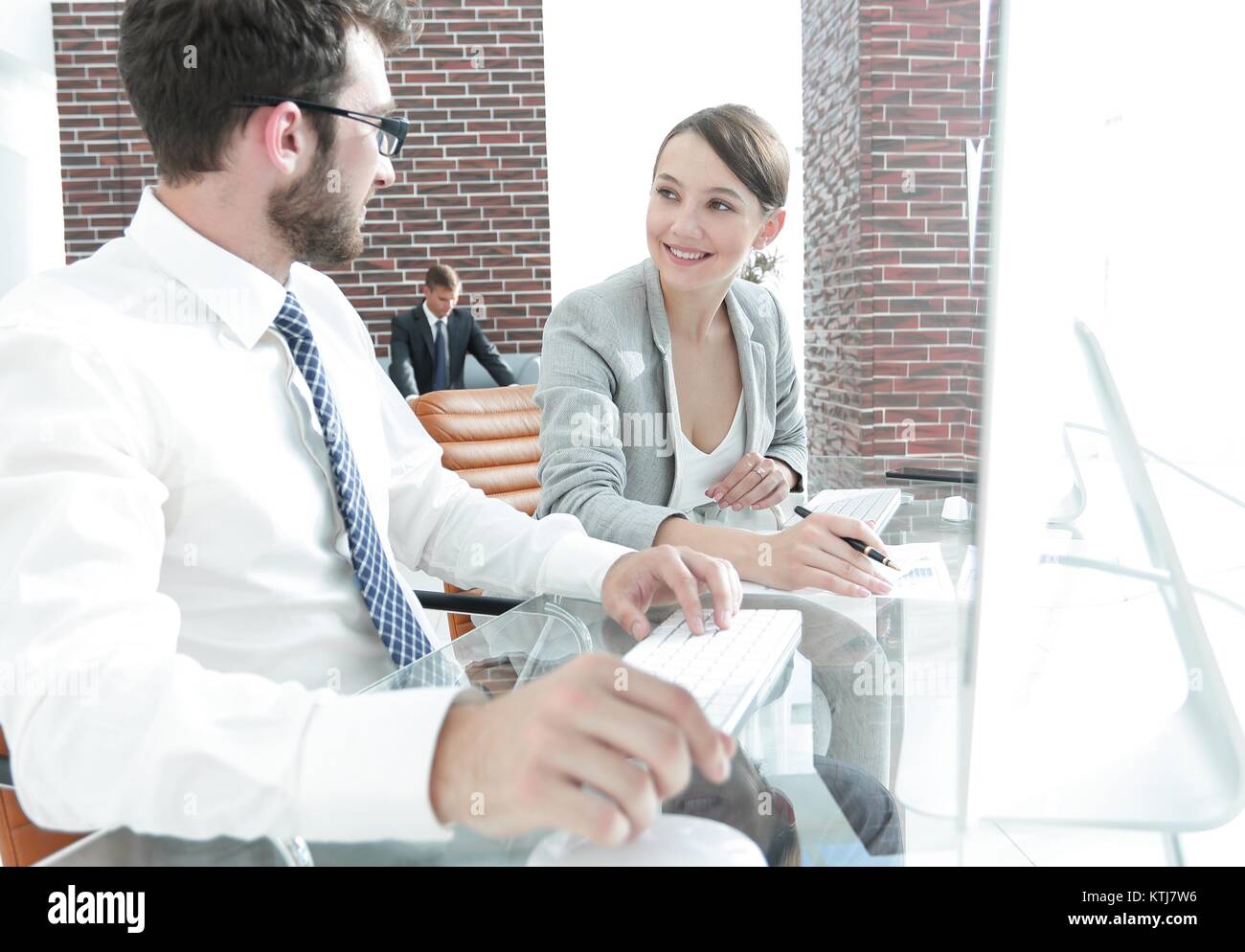 young professionals sitting behind a Desk Stock Photo - Alamy