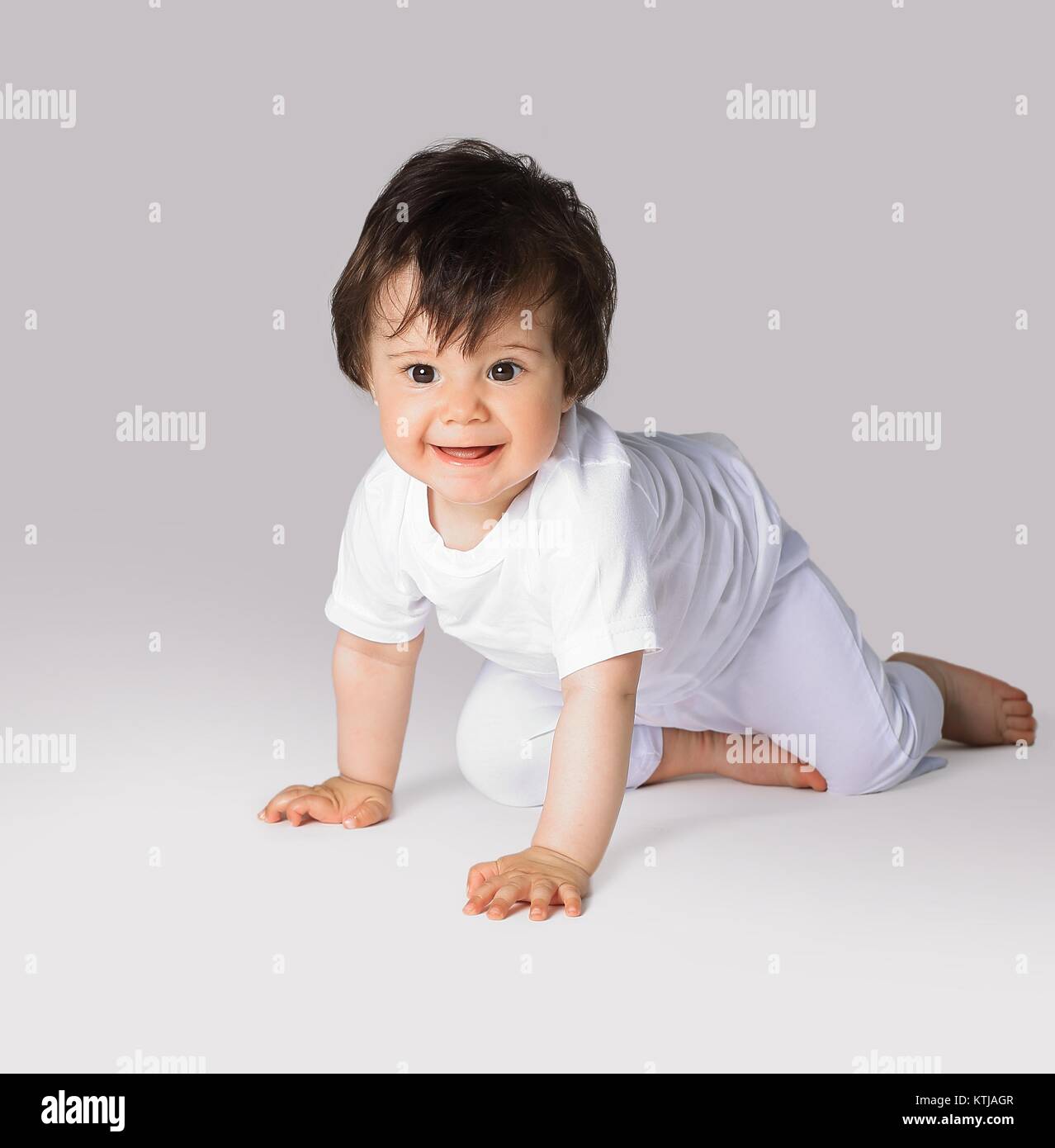 Happy crawling baby. Side view Stock Photo - Alamy