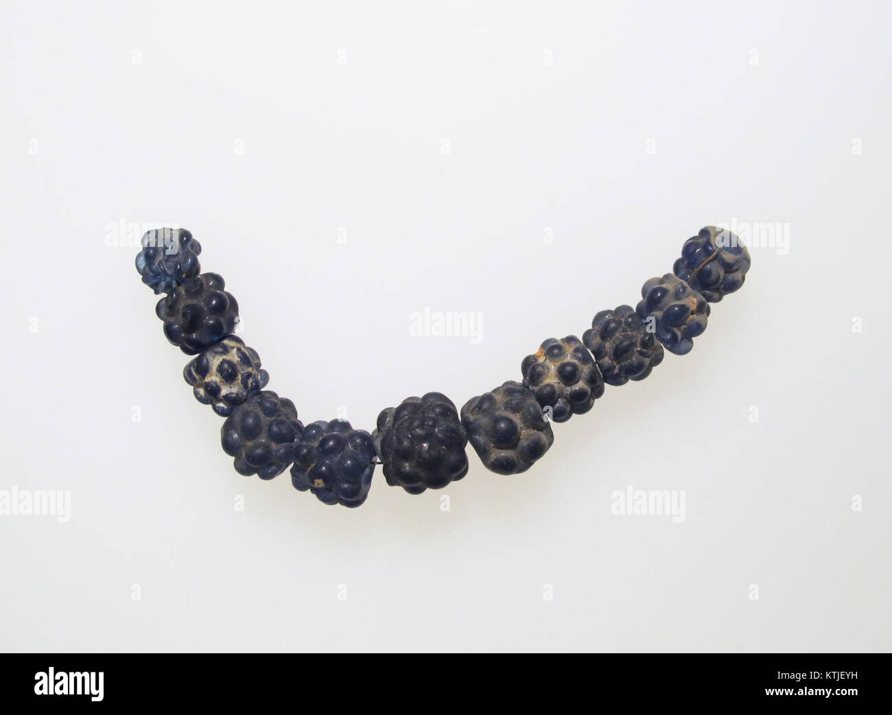 A collection of 11 beads, each with a unique color, displayed under ...